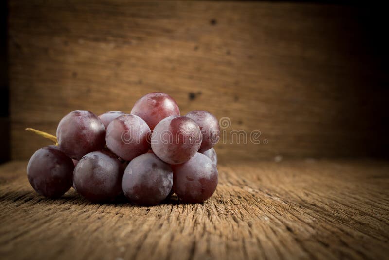 Red grapes on wooden table stock photo. Image of plant - 114878776