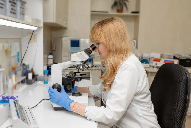 Red Hair Woman Lab Technician Looking through Microscope Analyse Blood ...