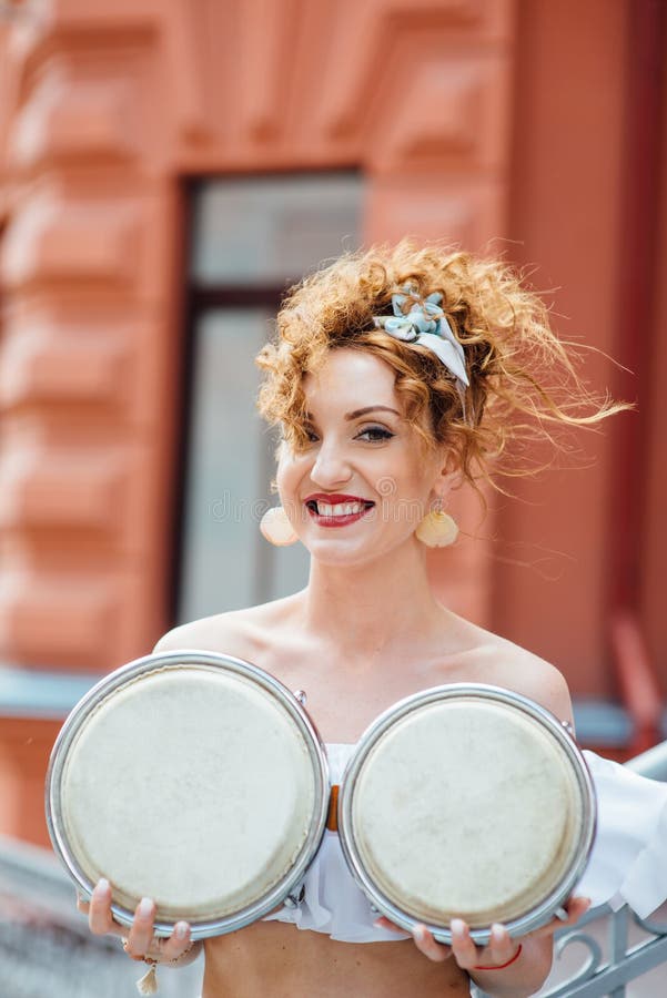 Red-haired Girl Covers Her Chest with Drums Stock Photo - Image of ...