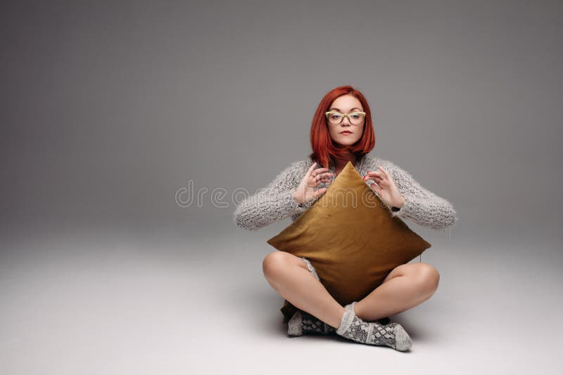 Red Haired Girl In Grey Sweater And Warm Socks Sitting On Floor In