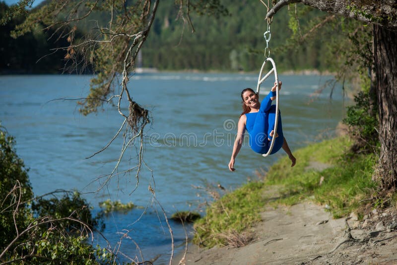 Red-haired Gymnast in a Blue Suit Doing the Difficult Exercises at the ...