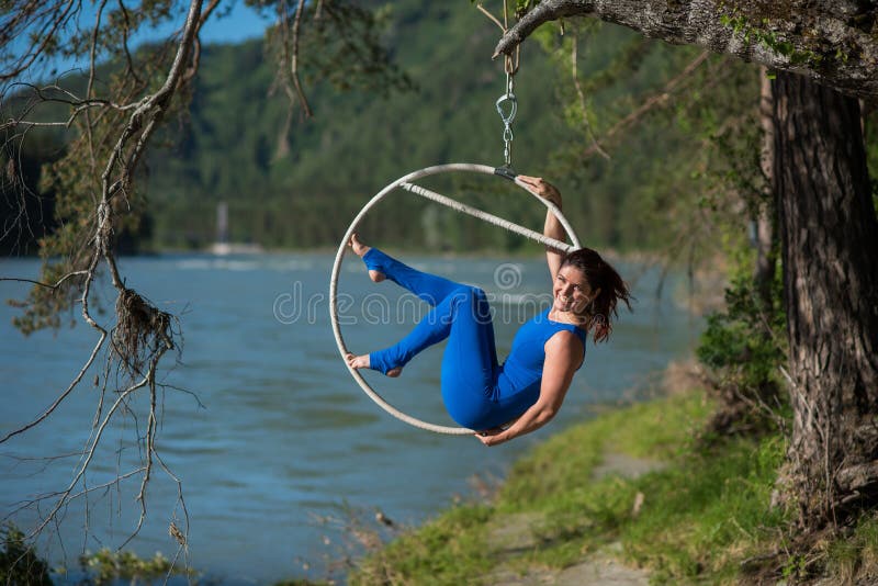 Red-haired Gymnast in a Blue Suit Doing the Difficult Exercises at the ...