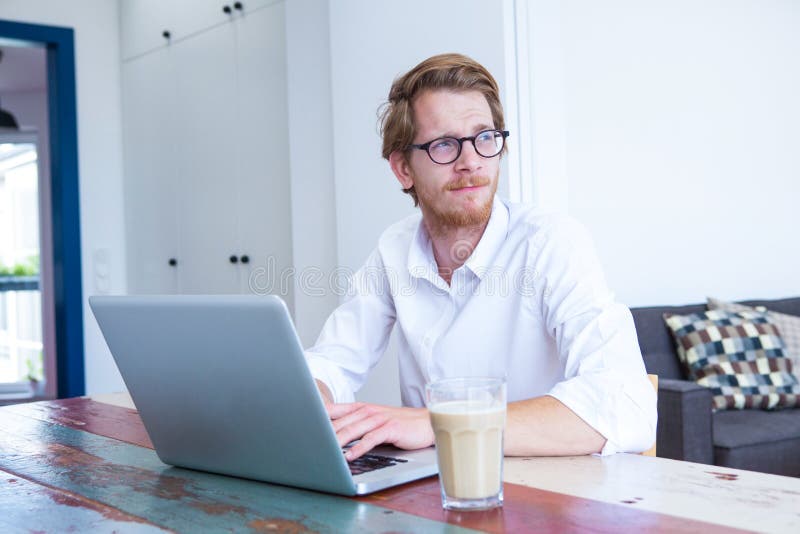 Red-haired Young Man Sitting at Table with His Laptop Stock Photo ...