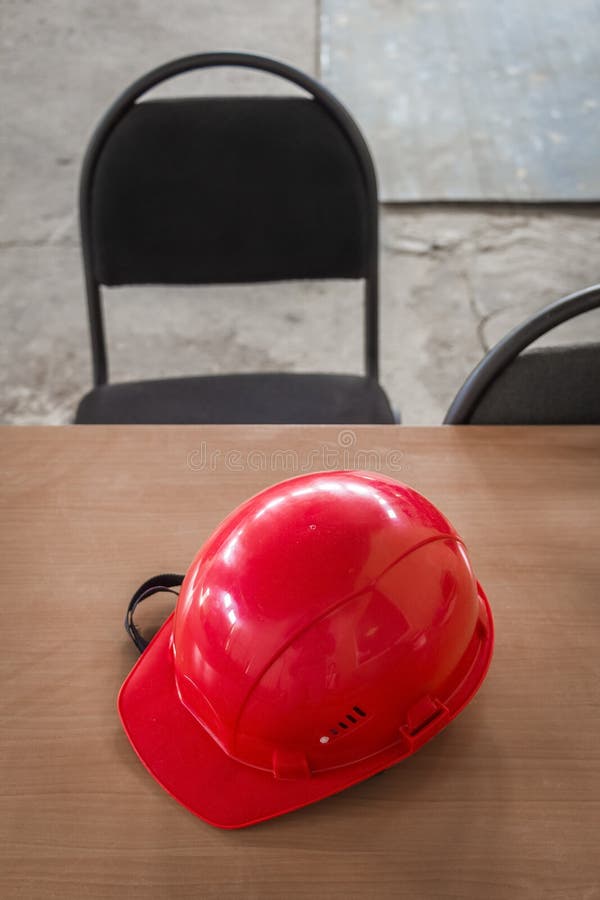 Red hard hat on a table. stock photo. Image of occupational - 76594318