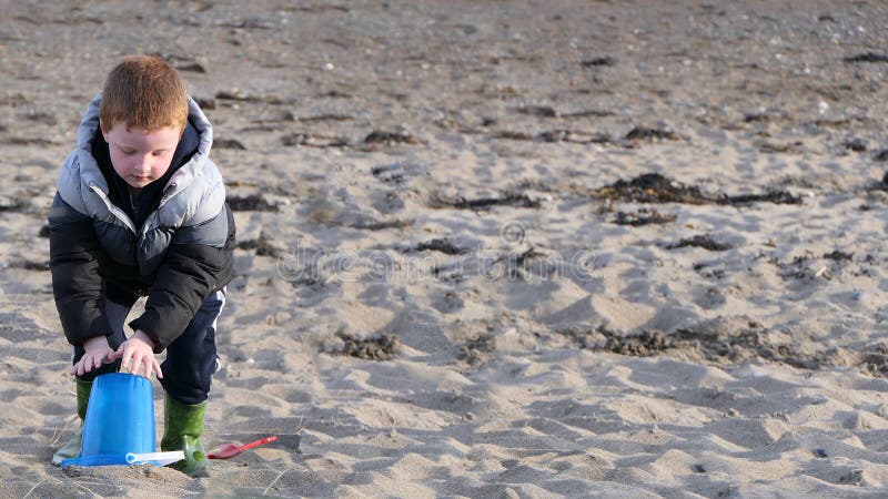 Red Headed Boy Playing with Bucket Spade and Digger on Sandy Beach ...