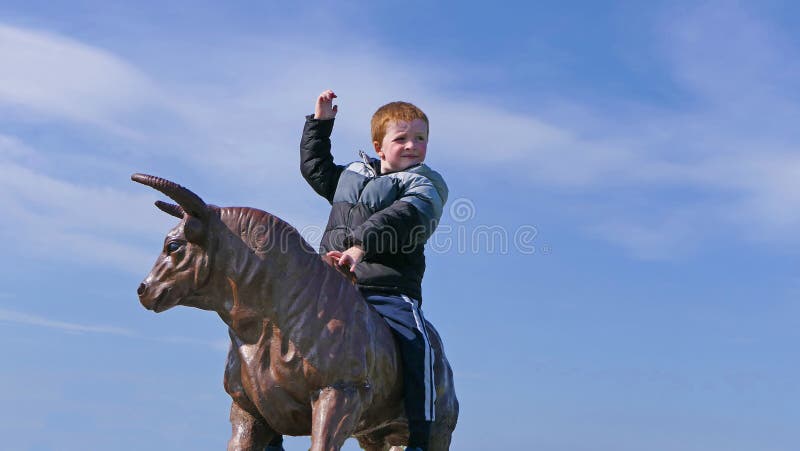 Red Headed Boy Riding a Statue Bull Ireland Stock Photo - Image of ...