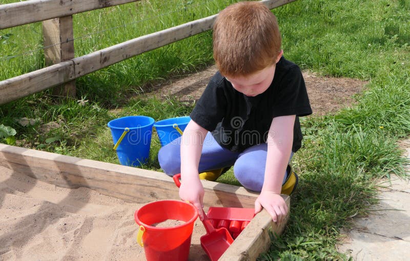 Red Headed Child Playing with Toys in Sand Pit Stock Image - Image of ...