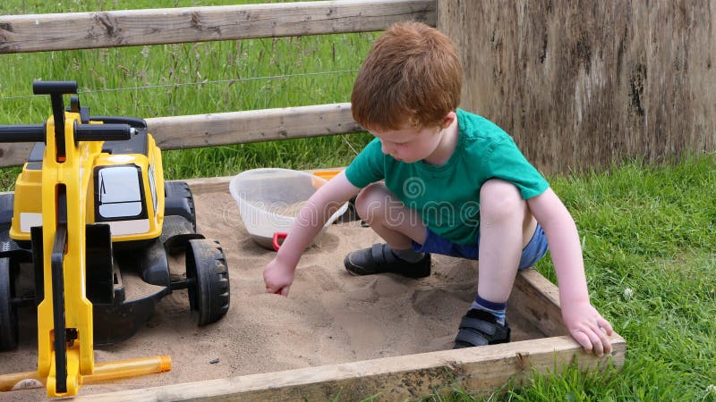 Red Headed Child Playing with Toys in Sand Pit Stock Photo - Image of ...