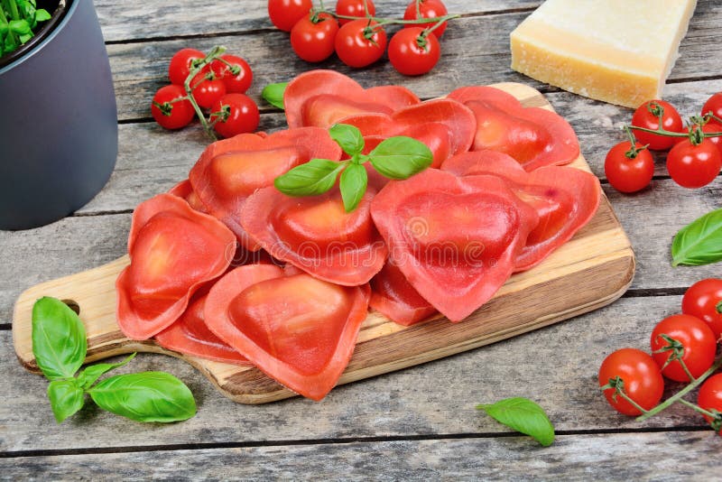 Red Heart Ravioli with Tomato, Mozzarella and Basil on Table Stock ...