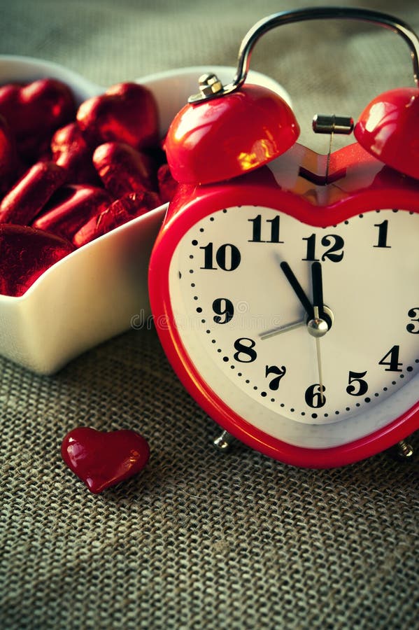 Red Heart Shaped Clock with Sweet Chocolates Stock Photo - Image of ...