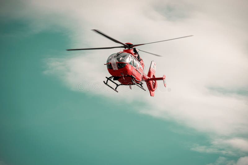 Red Helicopter in Flight with a Visible Spinning Propeller Against a ...