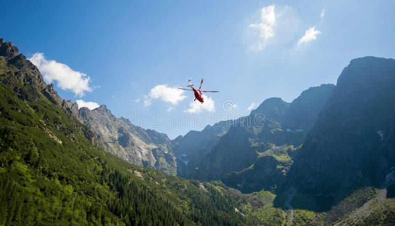 Red Helicopter is Flying between Mountains Peak, Summer Time Stock ...