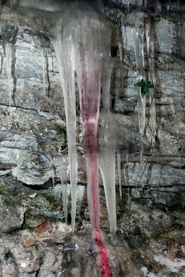 Red icicle on stone wall stock photo. Image of frosty - 181968202