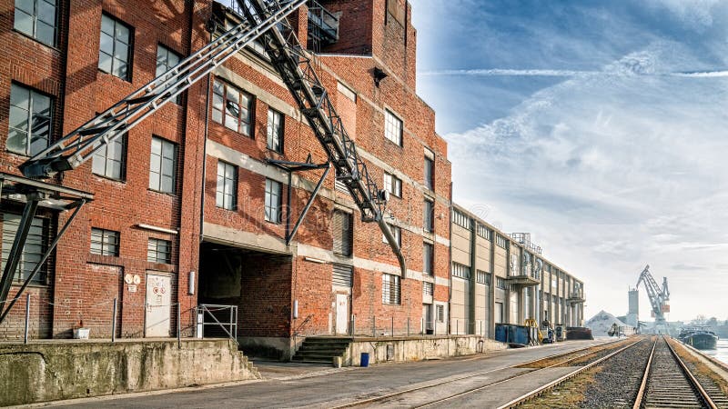 A Red Industrial Brick Building on a Port Envelope with Railroad Tracks ...