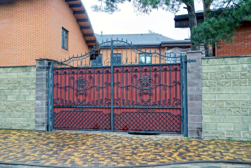 Red Iron Gate with a Wrought-iron Pattern with a Stone Fence in the ...