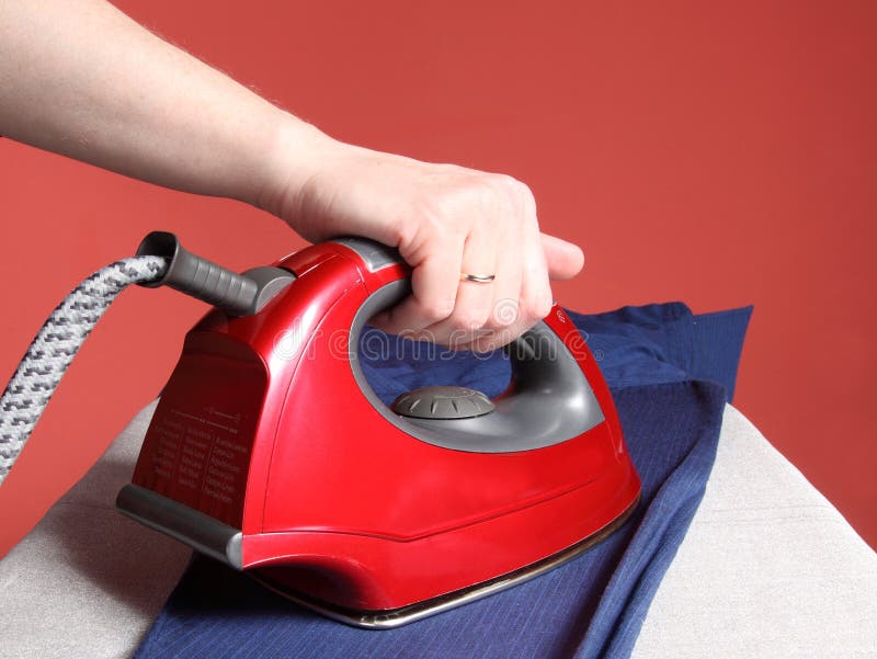 Red Iron in hand and shirt stock image. Image of laundry - 28263021