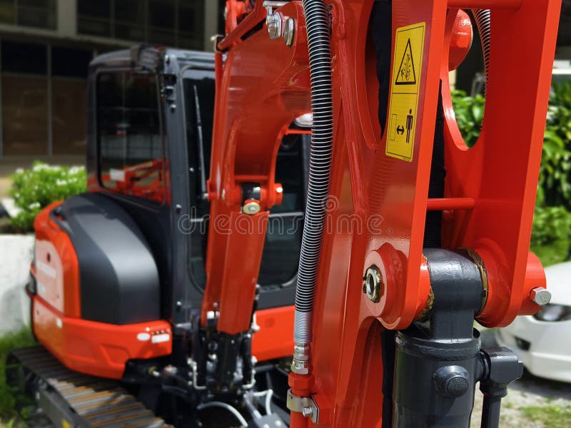 Red Large Excavators are Stationed in a Green Field in Front of a ...