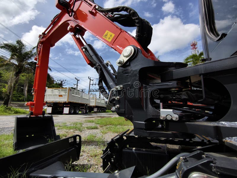 Red Large Excavators are Stationed in a Green Field in Front of a ...