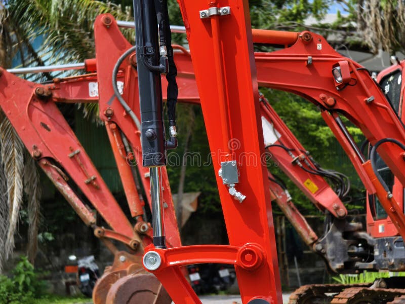 Red Large Excavators are Stationed in a Green Field in Front of a ...