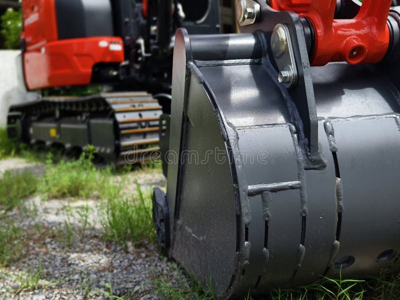 Red Large Excavators are Stationed in a Green Field in Front of a ...