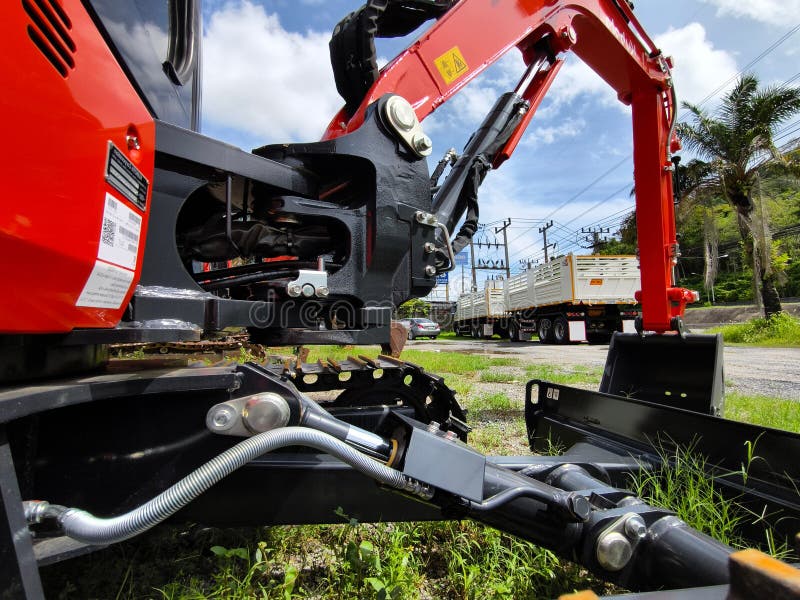 Red Large Excavators are Stationed in a Green Field in Front of a ...