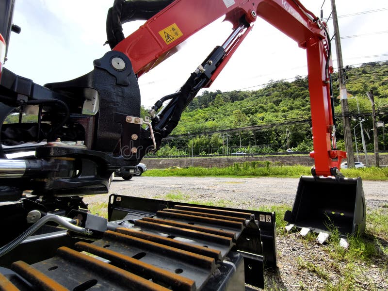 Red Large Excavators are Stationed in a Green Field in Front of a ...