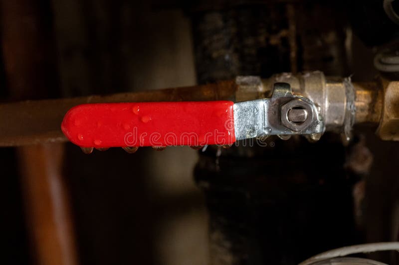 Red Lever Handle on Metal Pipe with Water Droplets in Industrial ...