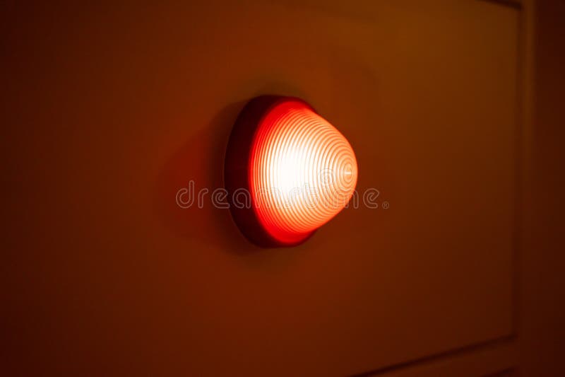 A Red Light Bulb Glowed on the Side Wall of the Room Stock Photo ...