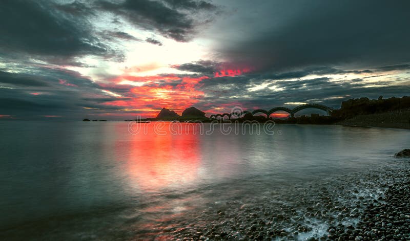 Red Light Falling on the Sea with Pebbles in the Beach Stock Photo ...