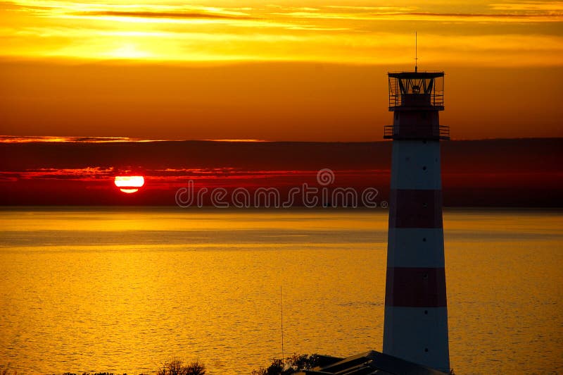 Red Lighthouse with Light Beam at Sunset. the Top Stock Image - Image ...