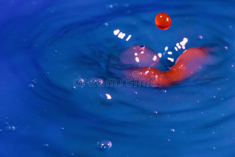 Red Liquid Drop Over Blue Liquid, Close Up Stock Photo - Image of light ...