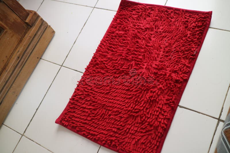 Red mat on the tiled floor stock photo. Image of cloth - 257880010