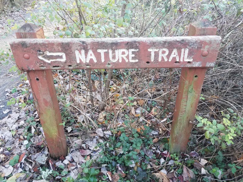 Red Nature Trail Sign with Left Arrow and Leaves Stock Photo - Image of ...