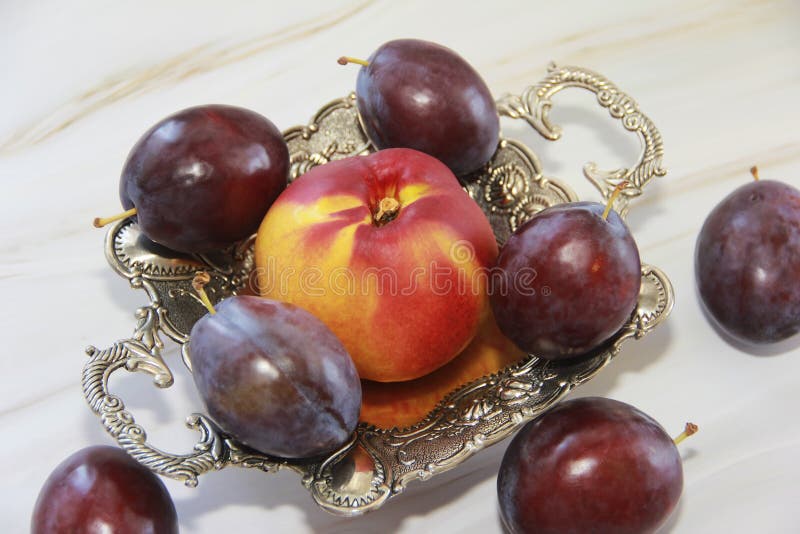 Red Nectarine and Burgundy Plums in a Decorative Plate Stock Image ...