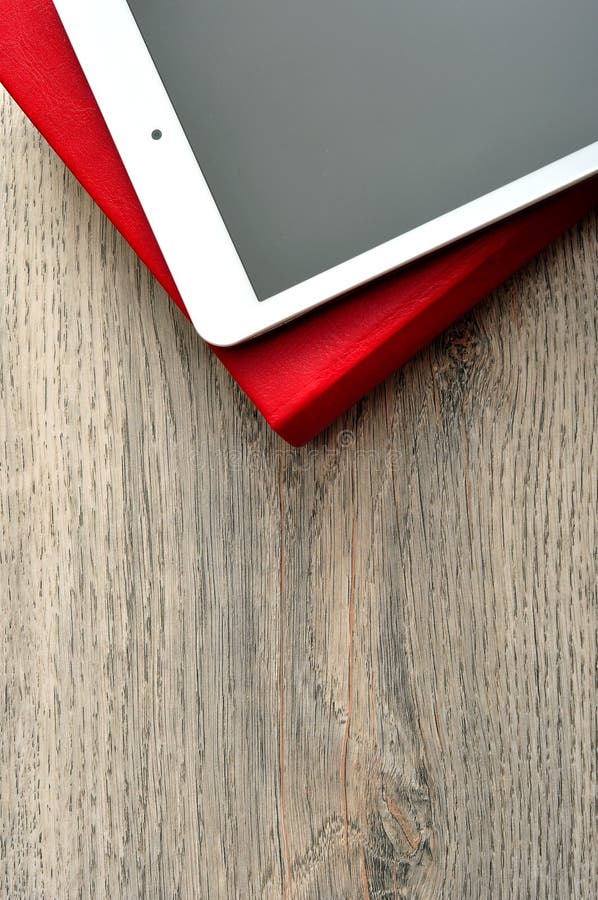Red Notebook and White Tablet on a Table with a Wooden Texture. Stock ...