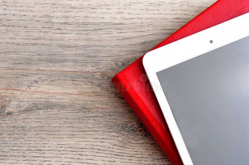 Red Notebook and White Tablet on a Table with a Wooden Texture. Stock ...