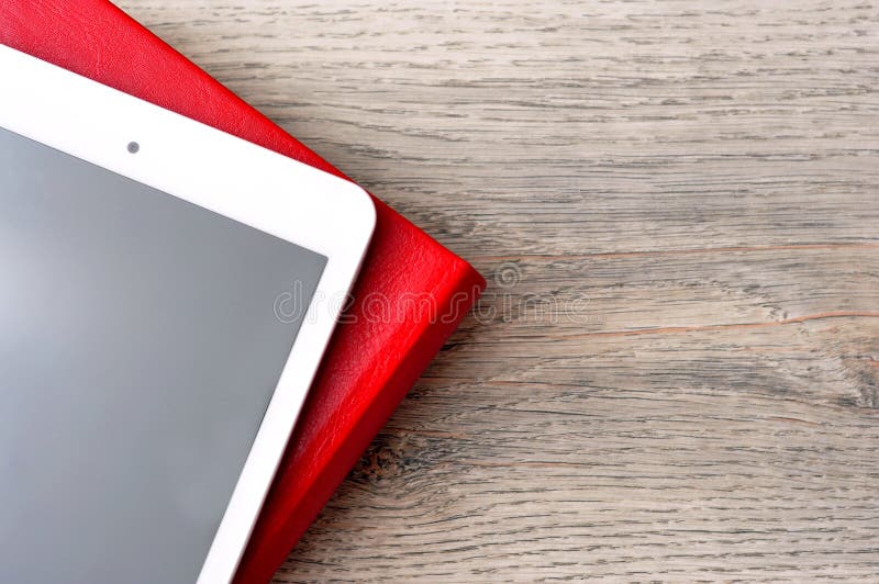 Red Notebook and White Tablet on a Table with a Wooden Texture. Stock ...