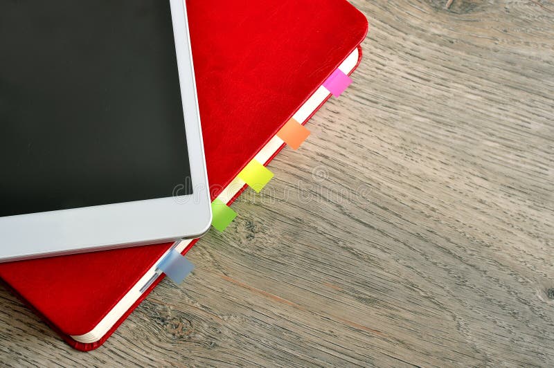 Red Notebook and White Tablet on a Table with a Wooden Texture. Stock ...