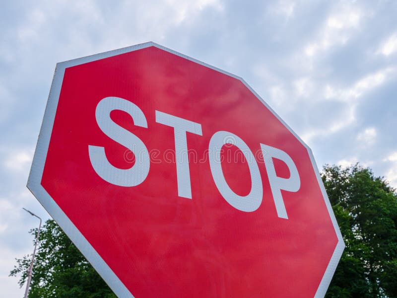 Red Octagonal Stop Sign Under a Cloudy Sky in a Residential Area Stock ...