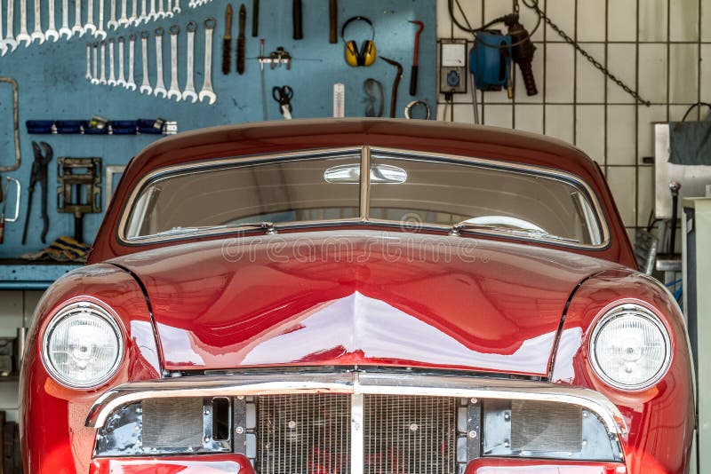 Red Oldtimer Car Parked in a Repair Shop in Front of a Wall with Screw ...