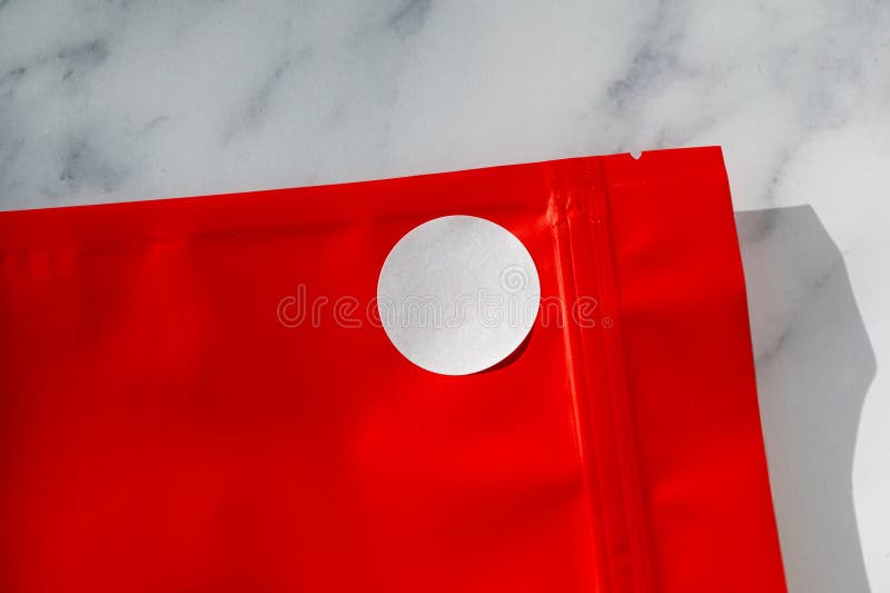 Red Packaging Pouch with White Circular Sticker on a Marble Surface ...