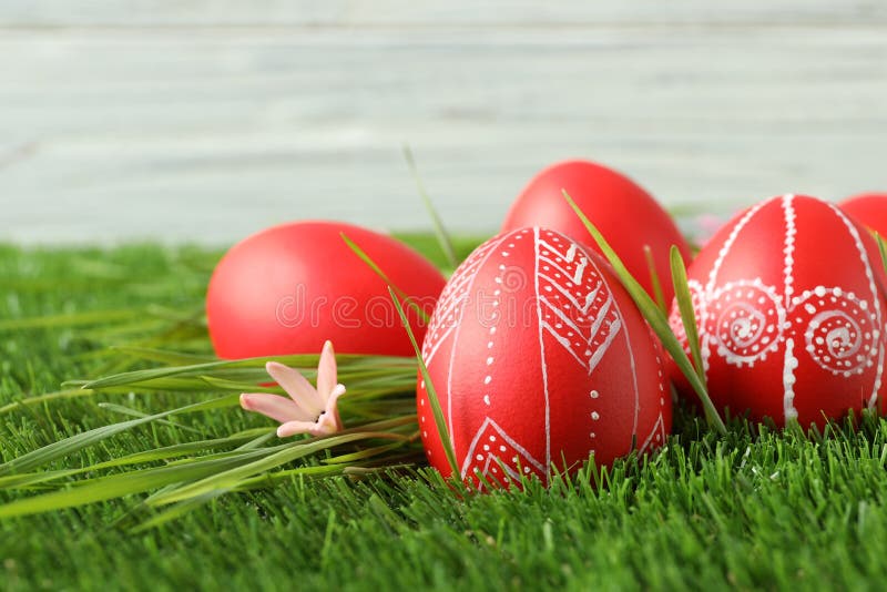 Red Painted Easter Eggs on Grass Against Light Background. Space for ...