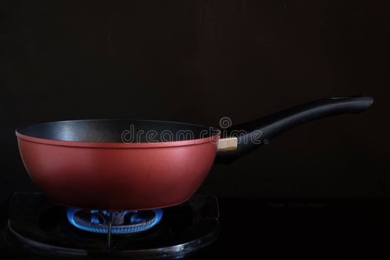 Red Pan on Gas Stove in Dark Tones Stock Image - Image of black, steam ...