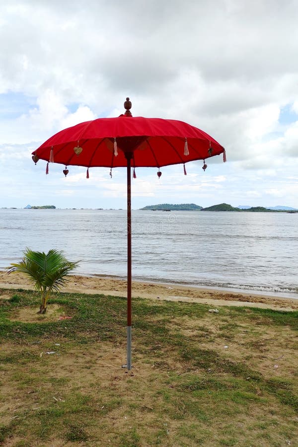 A Red Parasol Complete with Decorations Around it Stands Upright on the ...
