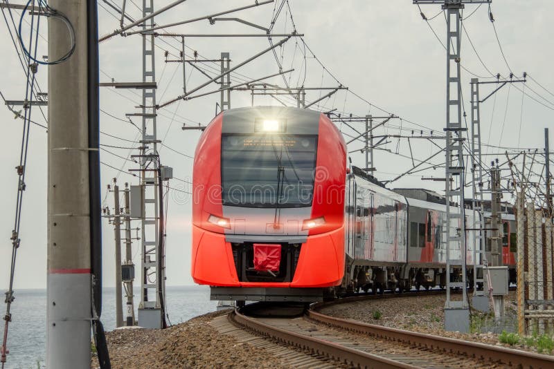 Red Passenger Train Turning on the Railroad on the Coast of the Sea ...