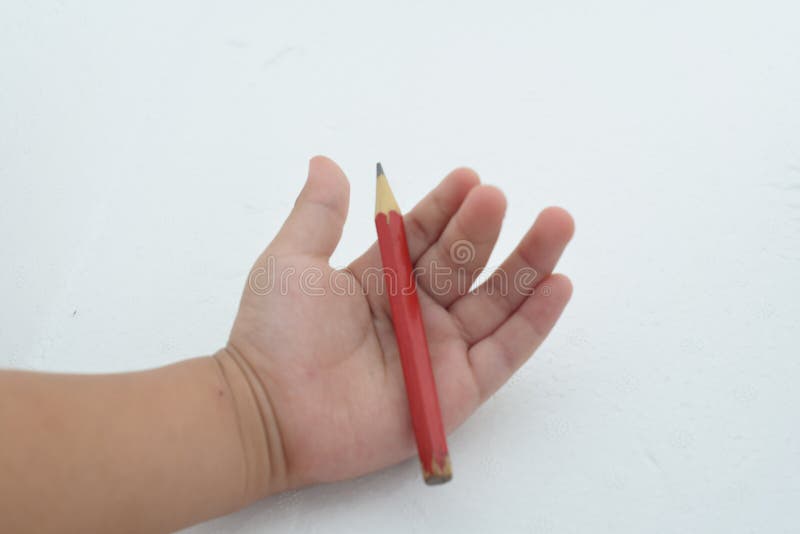 A Red Pencil on a Child& X27;s Hand with White Background Stock Image ...