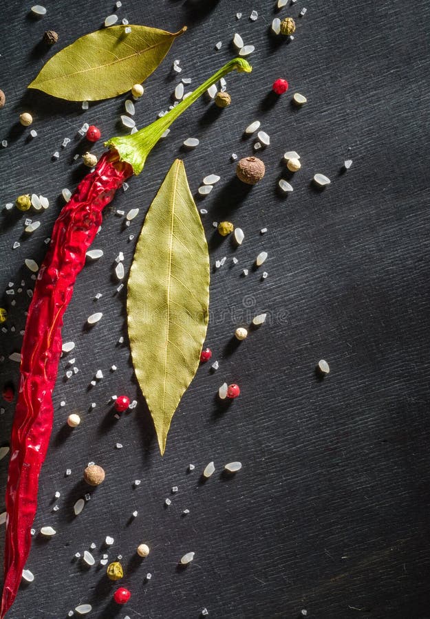 Red Pepper Pungent Spices and Bay Leaf on the Black Tree. View from ...