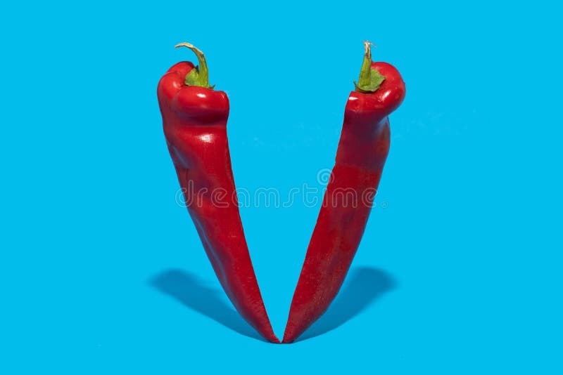 Red Pepper Split on Half Standing on Blue Background Stock Photo ...