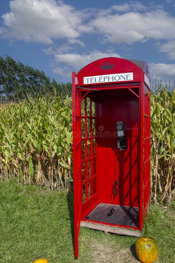 A Red Phone Booth in Front of a Corn Field with Pumpkins Editorial ...