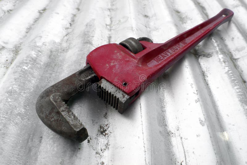 Red Pipe Wrench on Corrugated Iron Background Stock Photo - Image of ...